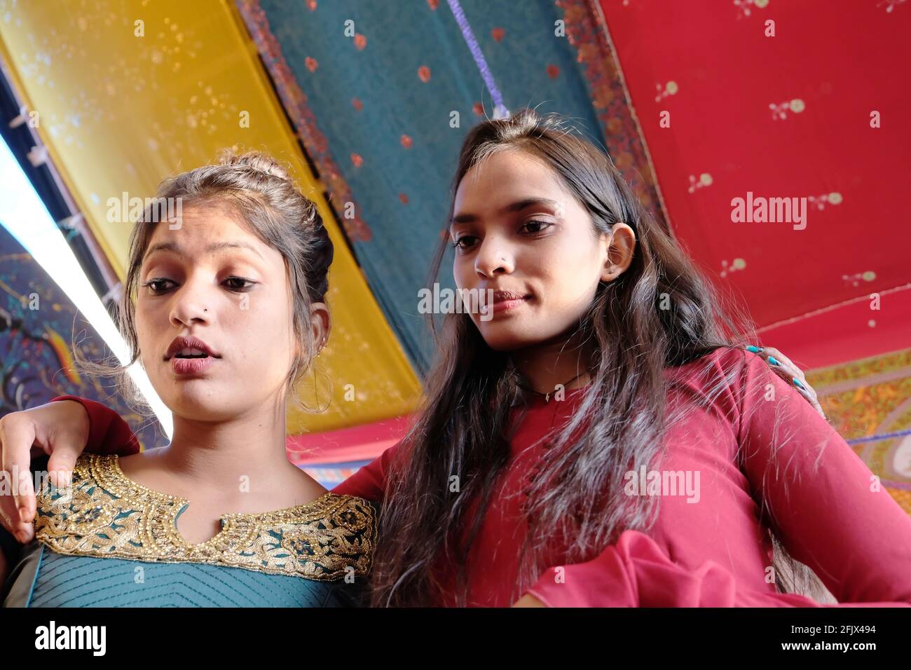 Low angle shot of two female South Asian friends in traditional dresses ...