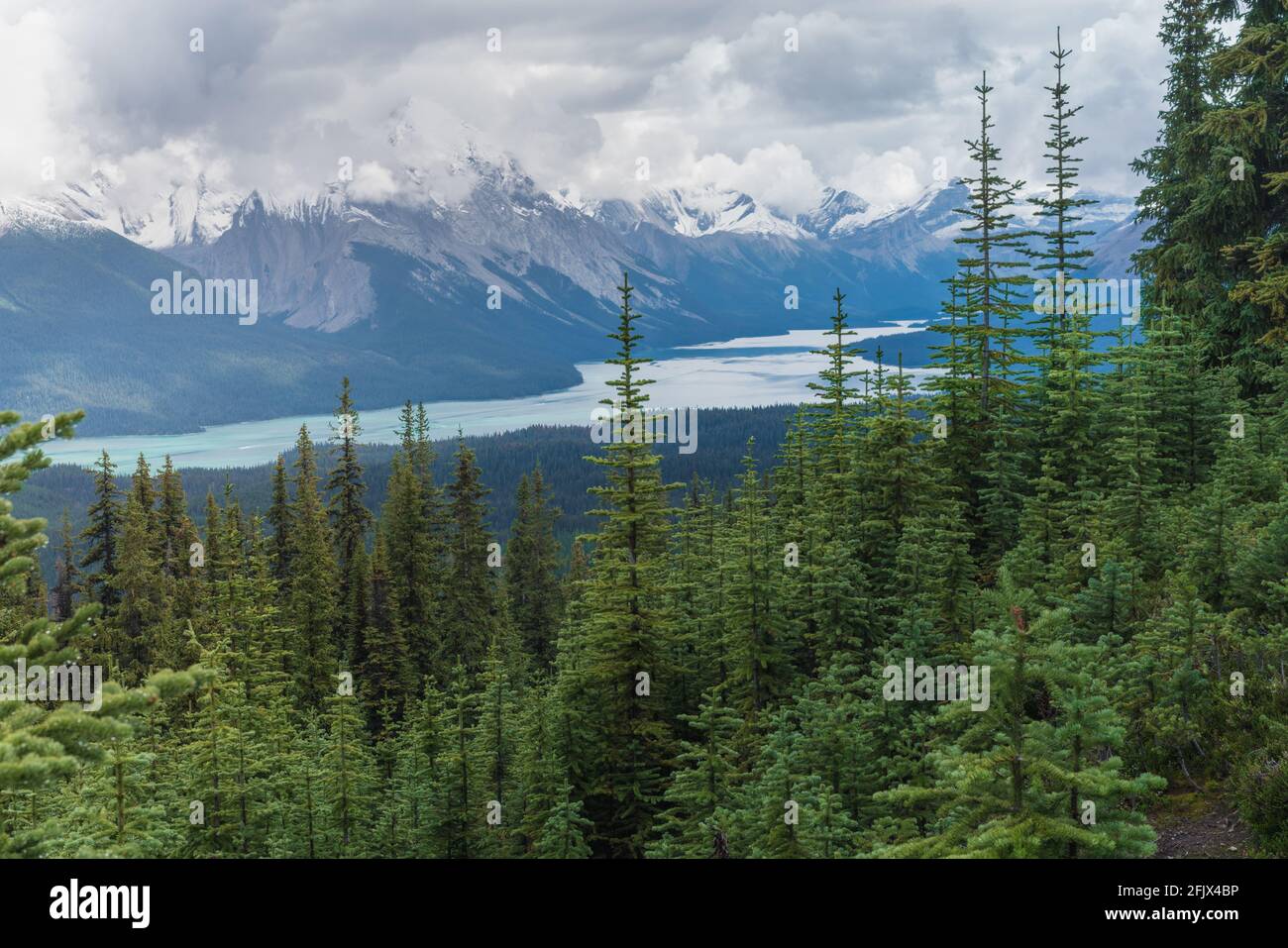 Clouds gathering above the mountain range in Canadian Rockies. Maligne ...