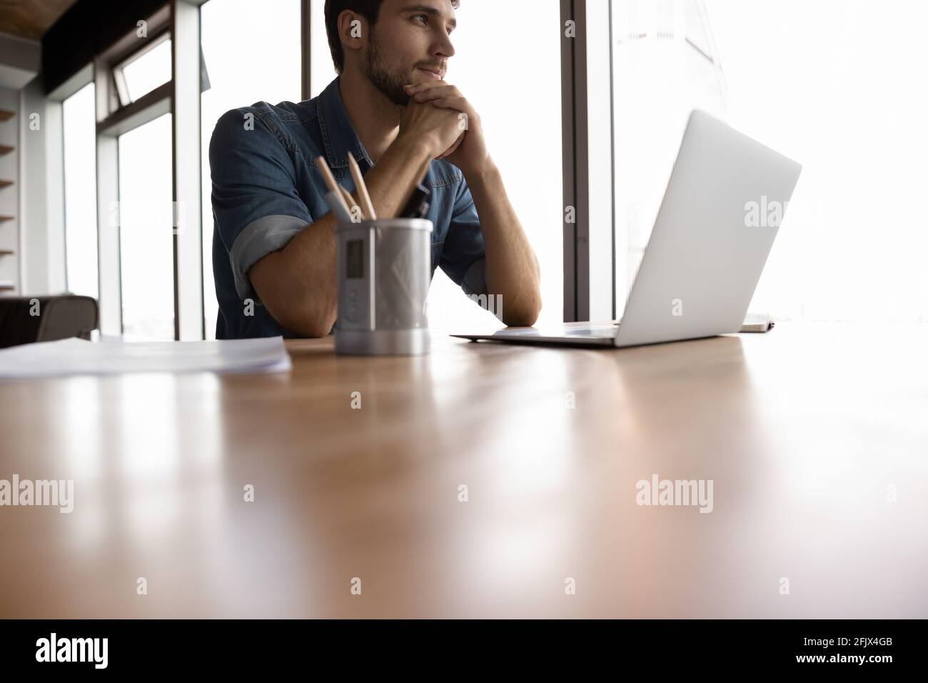 Pensive Caucasian man work on laptop thinking Stock Photo - Alamy