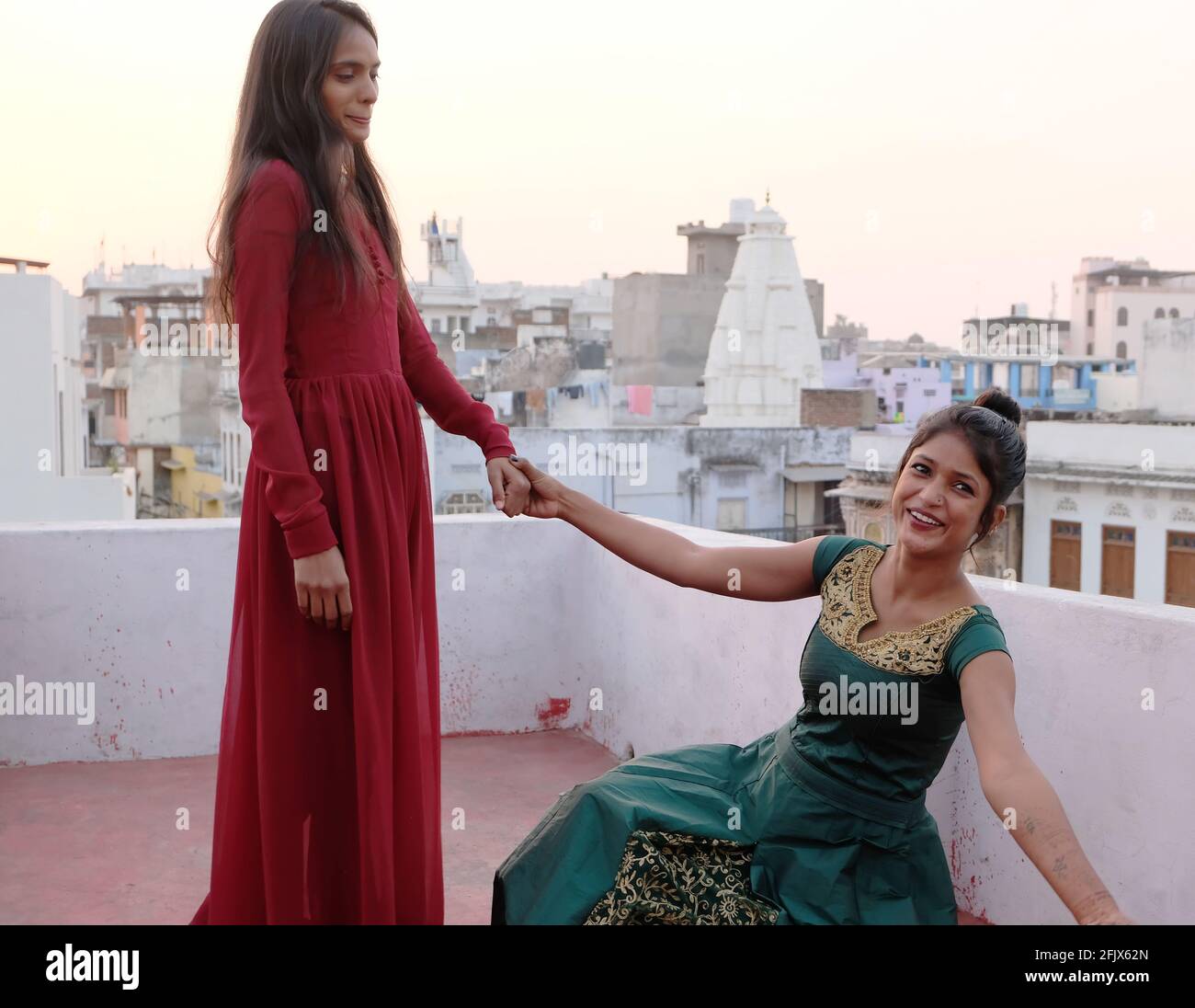 Two female South Asian friends in traditional dresses having fun ...