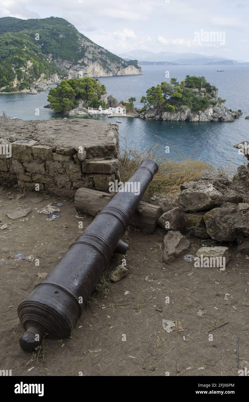 Vertical shot of a cannon on the shore with the sea in the background ...