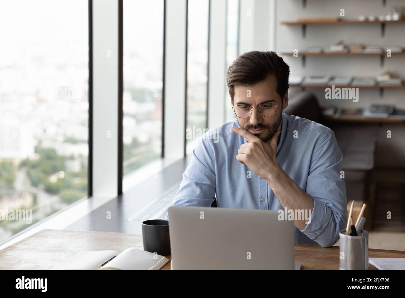 Serious male employee work on computer thinking Stock Photo - Alamy
