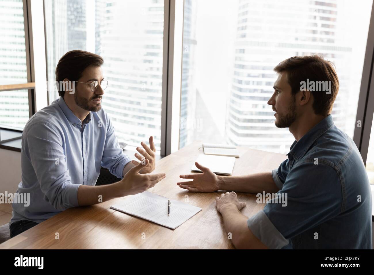 Caucasian male employer talk with colleague in office Stock Photo - Alamy