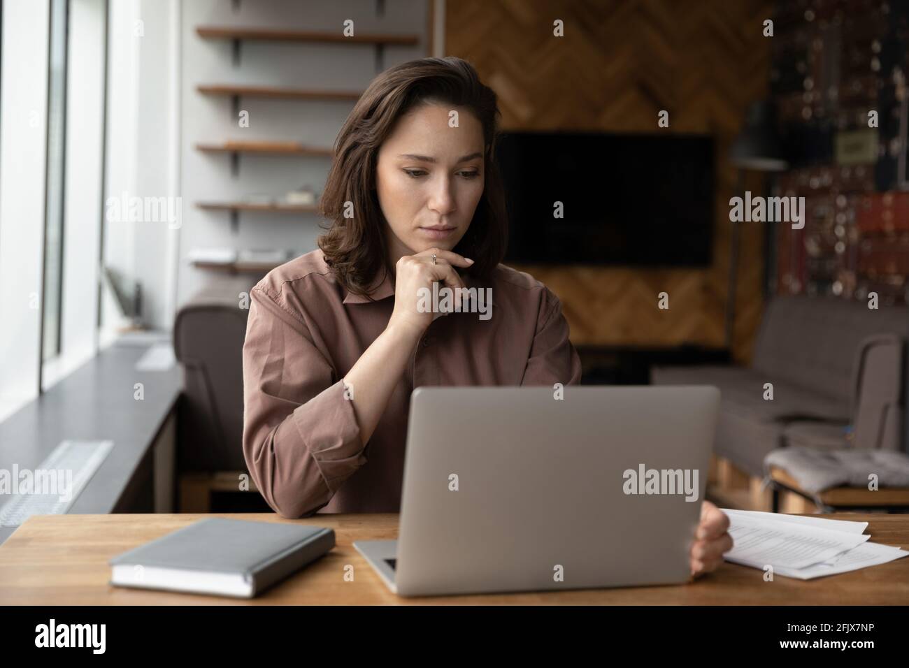 Pensive female worker busy browsing computer in office Stock Photo - Alamy