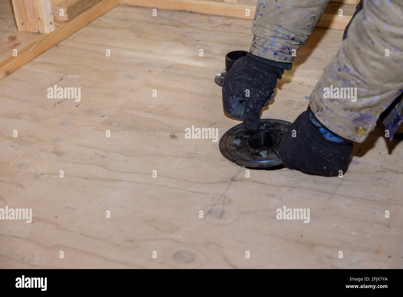 Plumber jointing installing sewage shower drain pipes on a house under ...