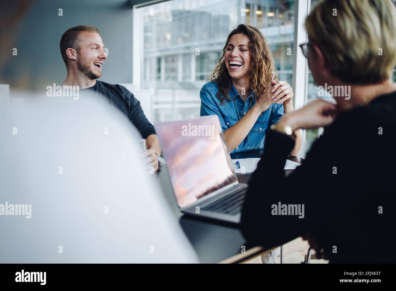 business professional having casual discussion and smiling during a ...