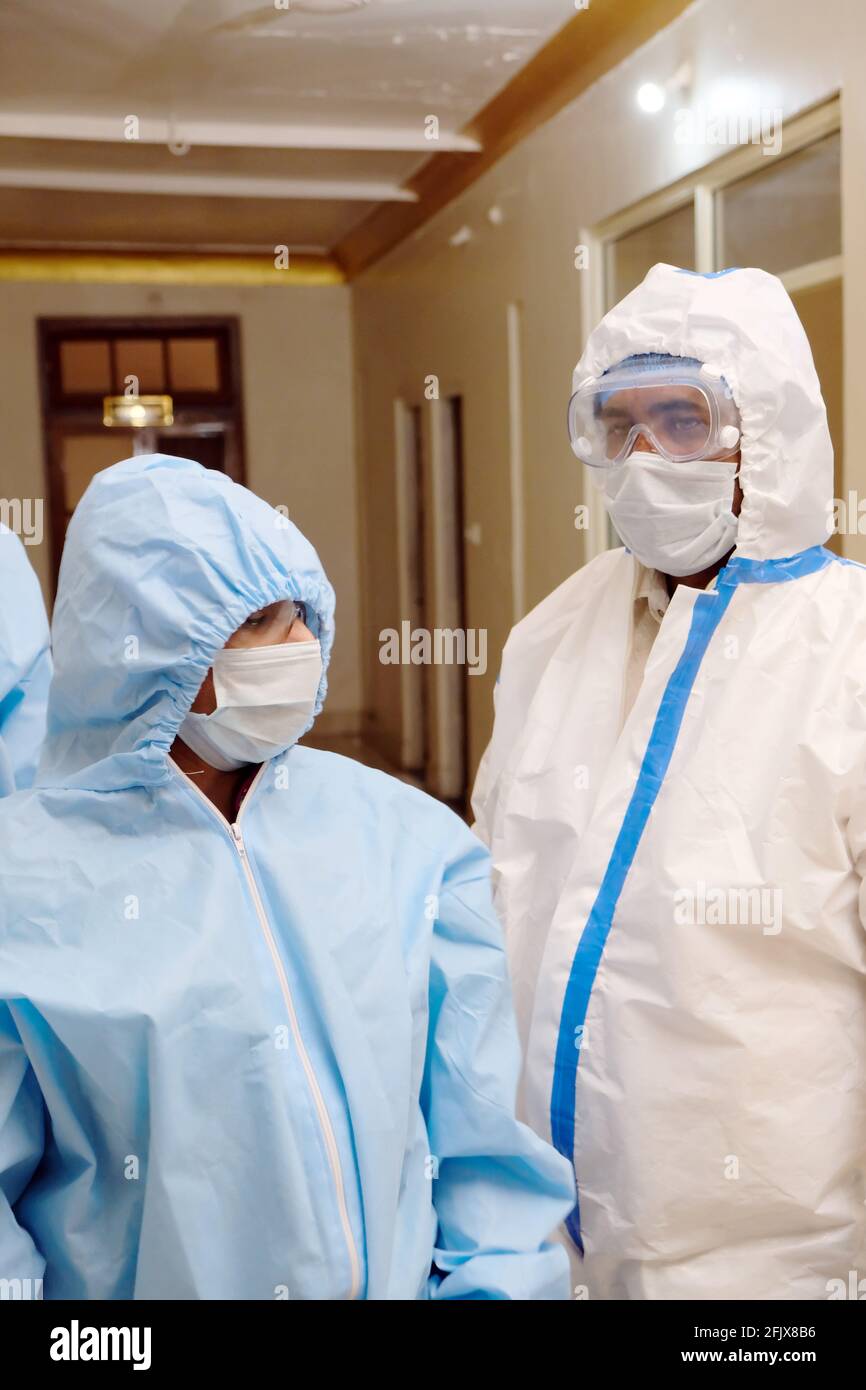 Vertical shot of the medical personnel in special protective costumes ...