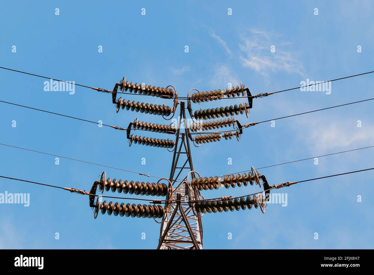 A low angle shot of overhead electric power lines with insulators Stock ...