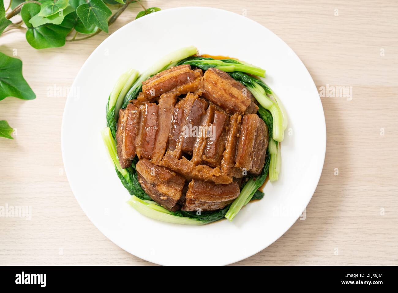 Braised pork belly with yam served with green vegetable Stock Photo - Alamy