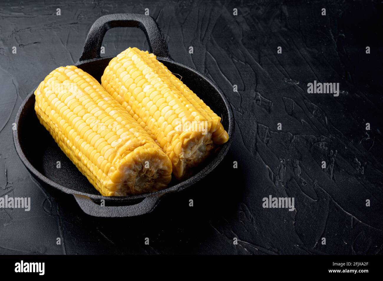 Homemade golden sweet corn cob set, on black stone background, with ...