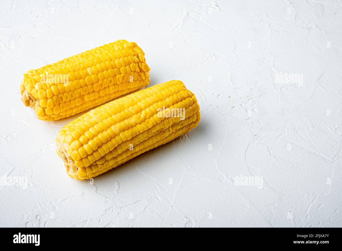 Tasty corn cobs set, on white stone background, with copy space for ...