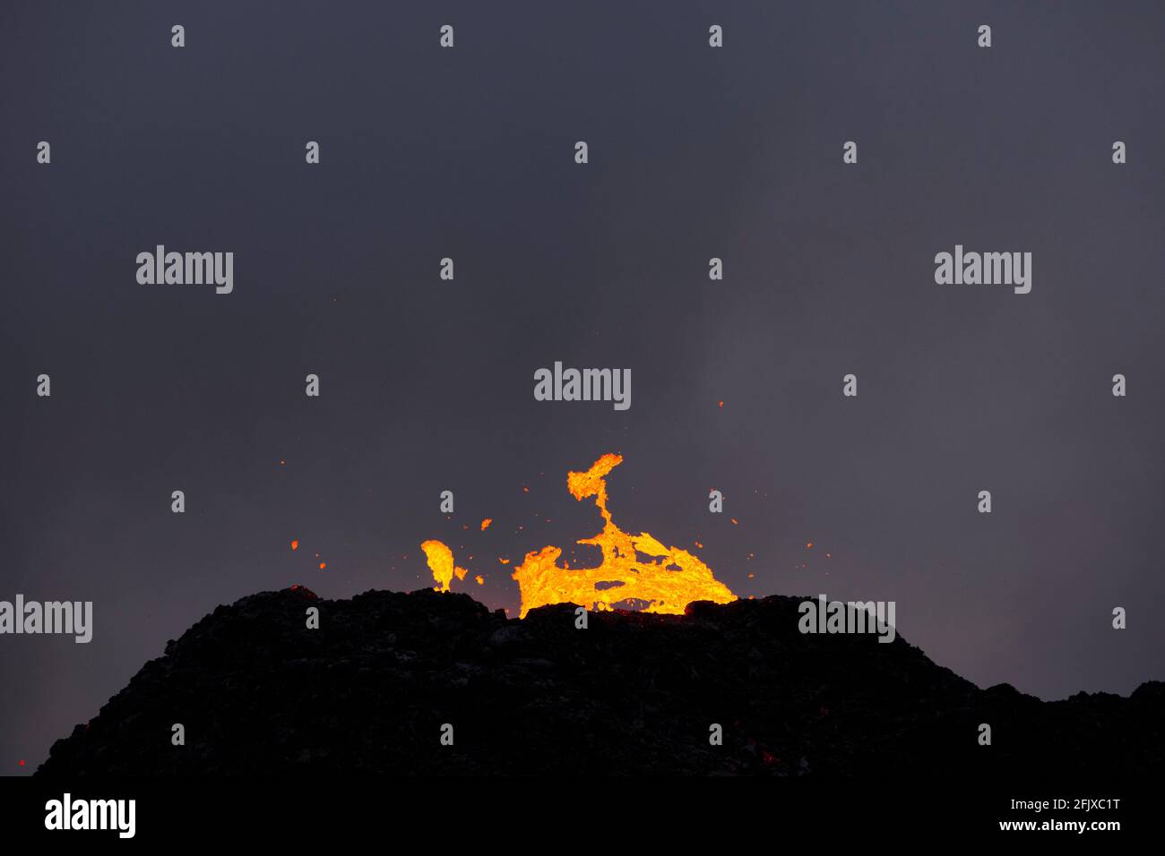 Volcano erupting on background of dark sky Stock Photo - Alamy