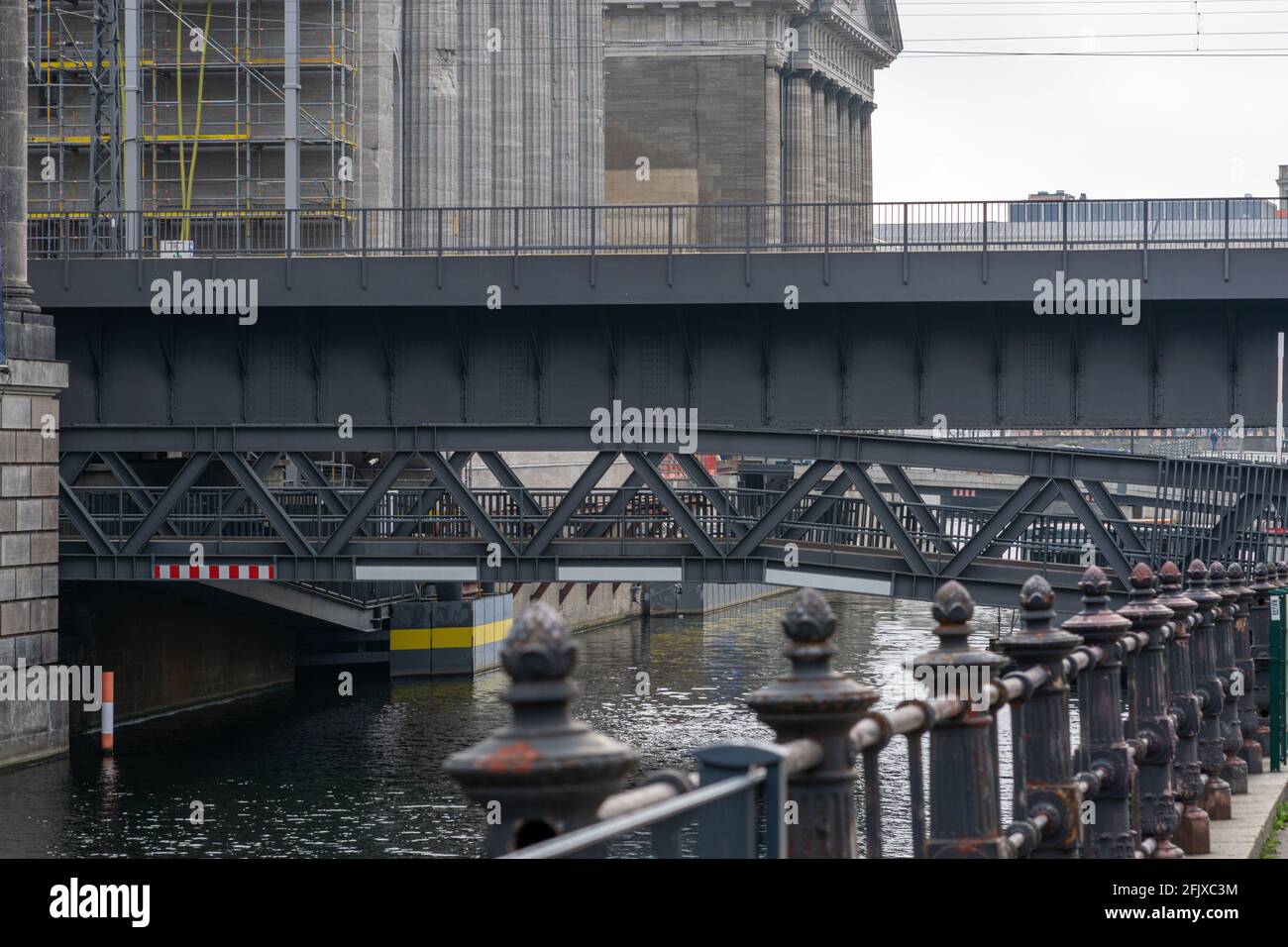 Bridge over a river in Berlin with building scaffolds in the background ...