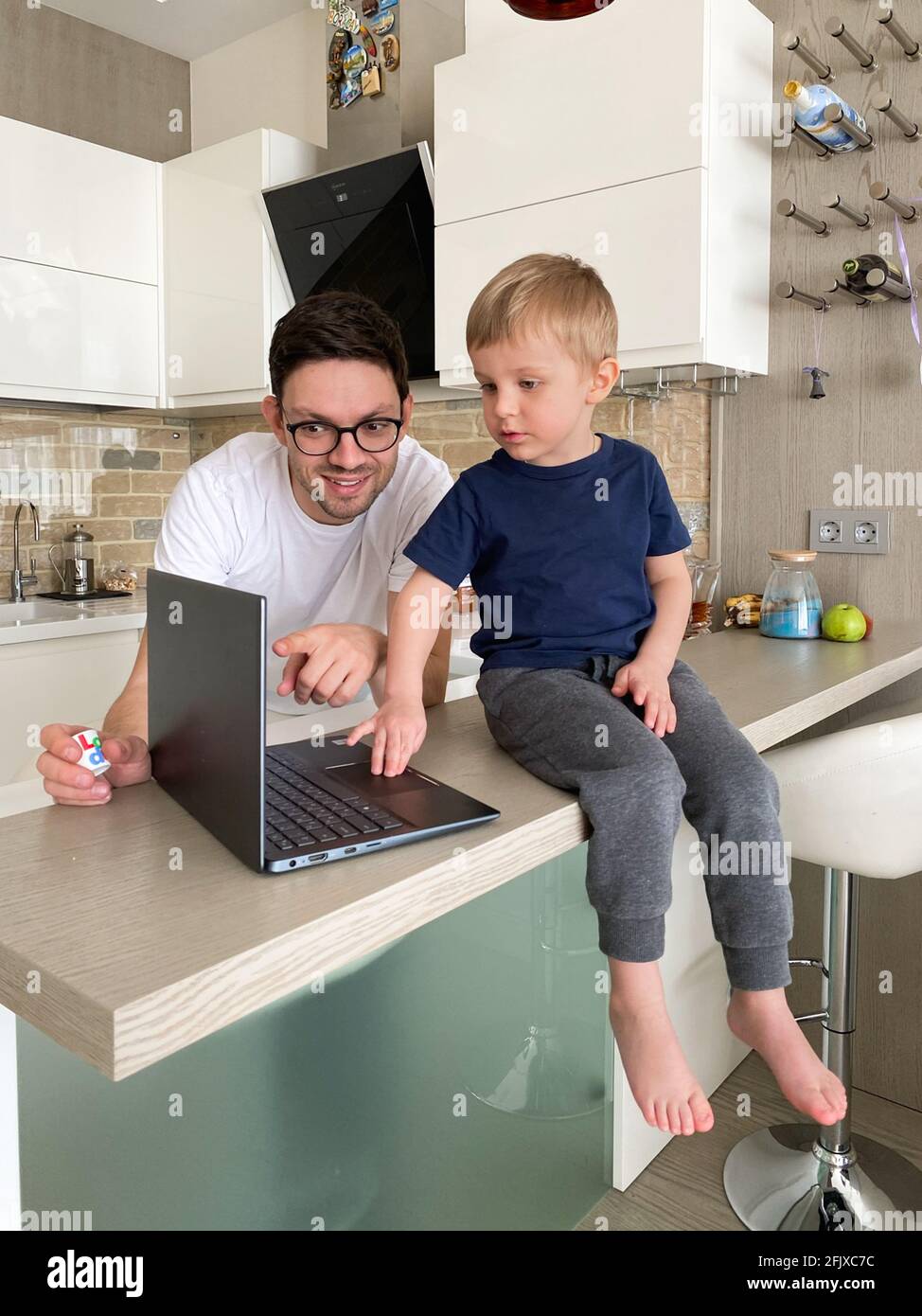 Father teaching his son on the notebook Stock Photo - Alamy
