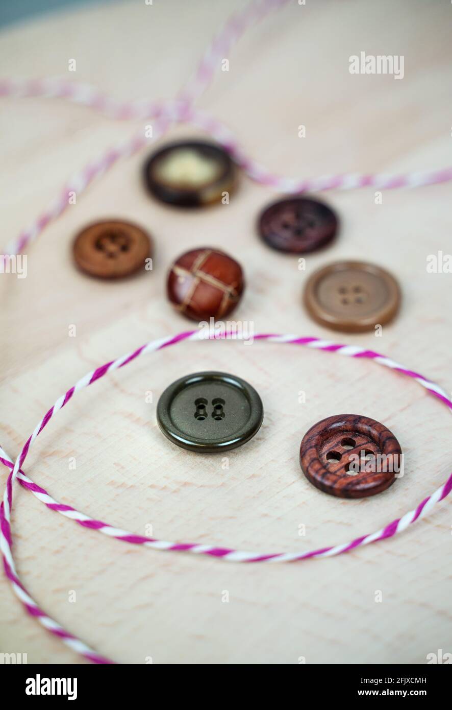Assorted buttons and striped string on light wood Stock Photo - Alamy
