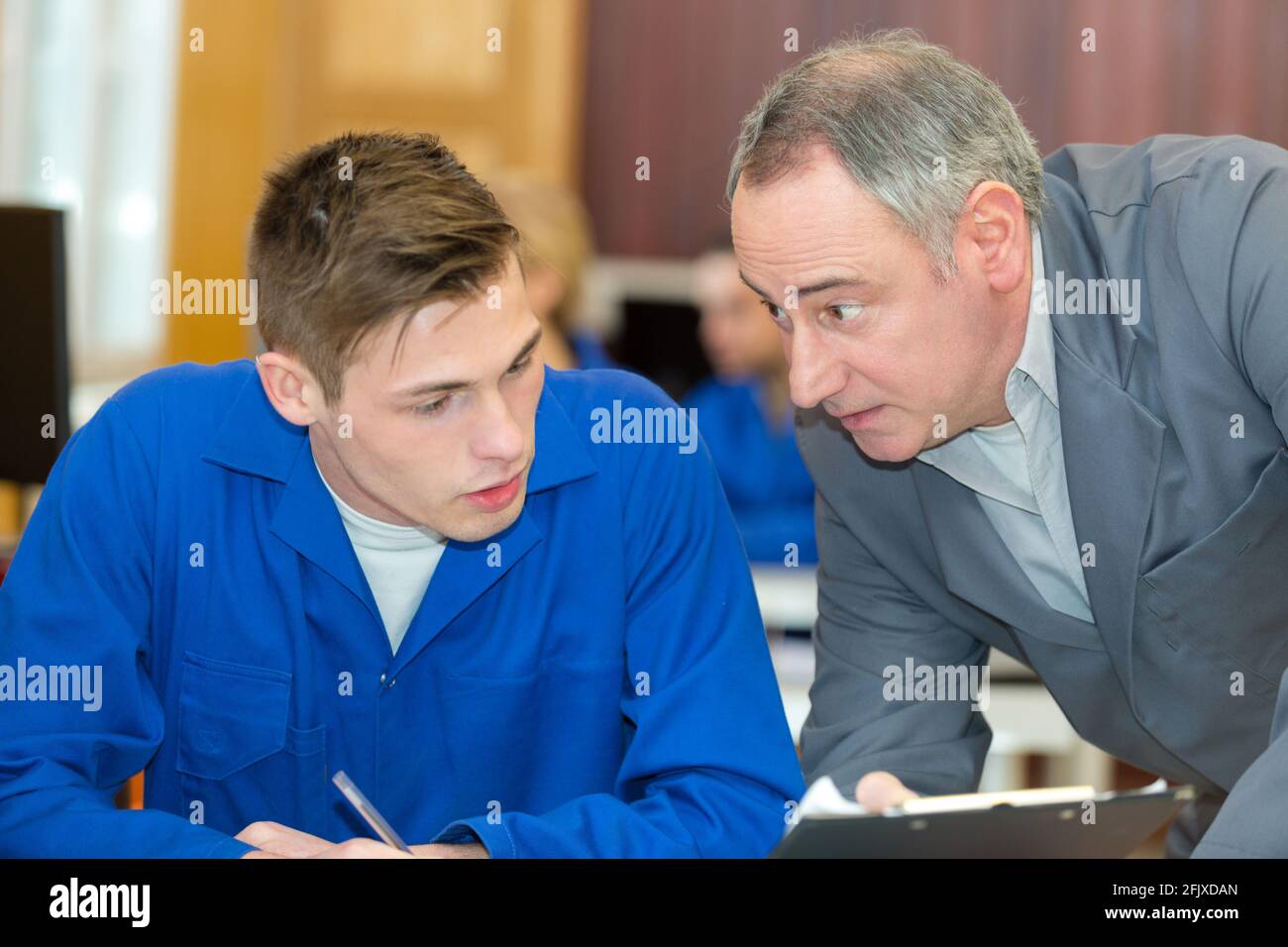 apprentice taking notes on important information Stock Photo - Alamy