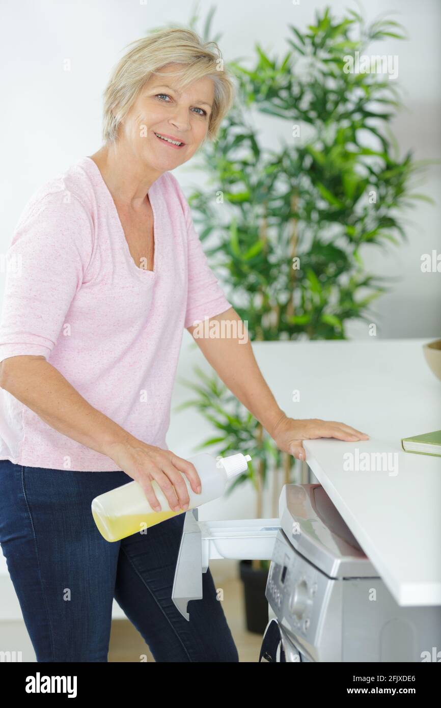 senior woman loading washing machine at home Stock Photo - Alamy
