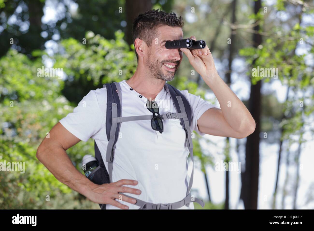 man with binoculars standing in the woods Stock Photo - Alamy