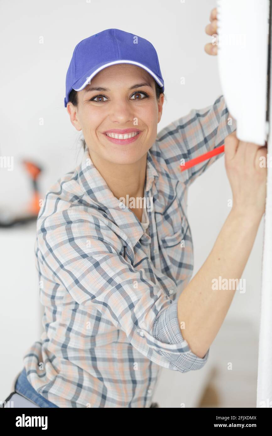 female worker marking position on wall Stock Photo - Alamy
