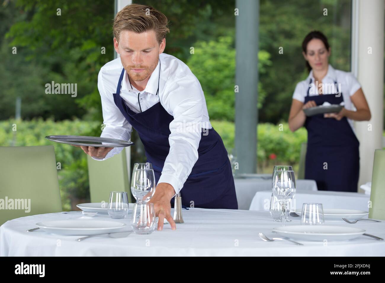 portrait of waiter setting table Stock Photo - Alamy