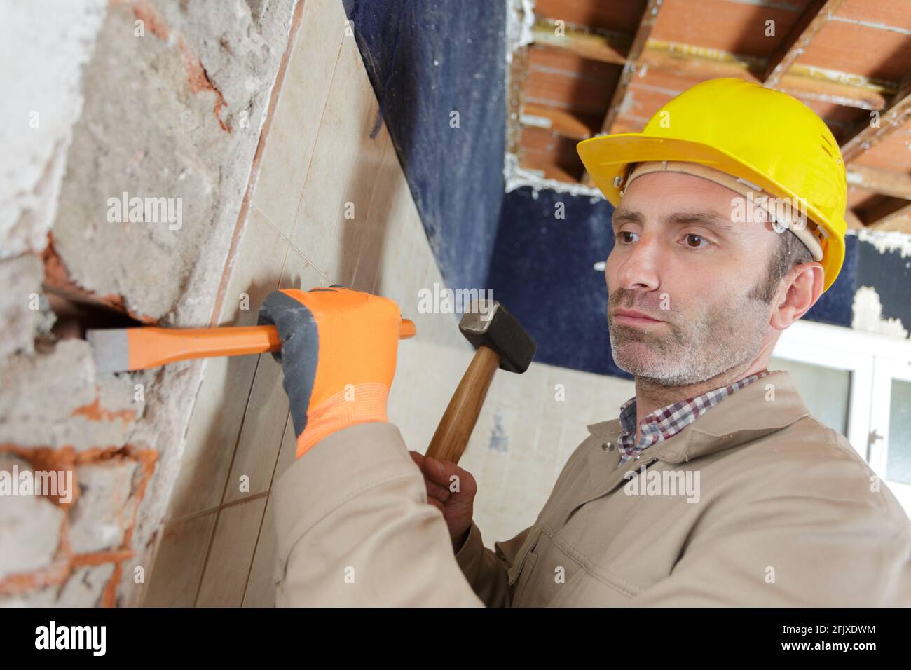 male builder breaking a wall Stock Photo - Alamy
