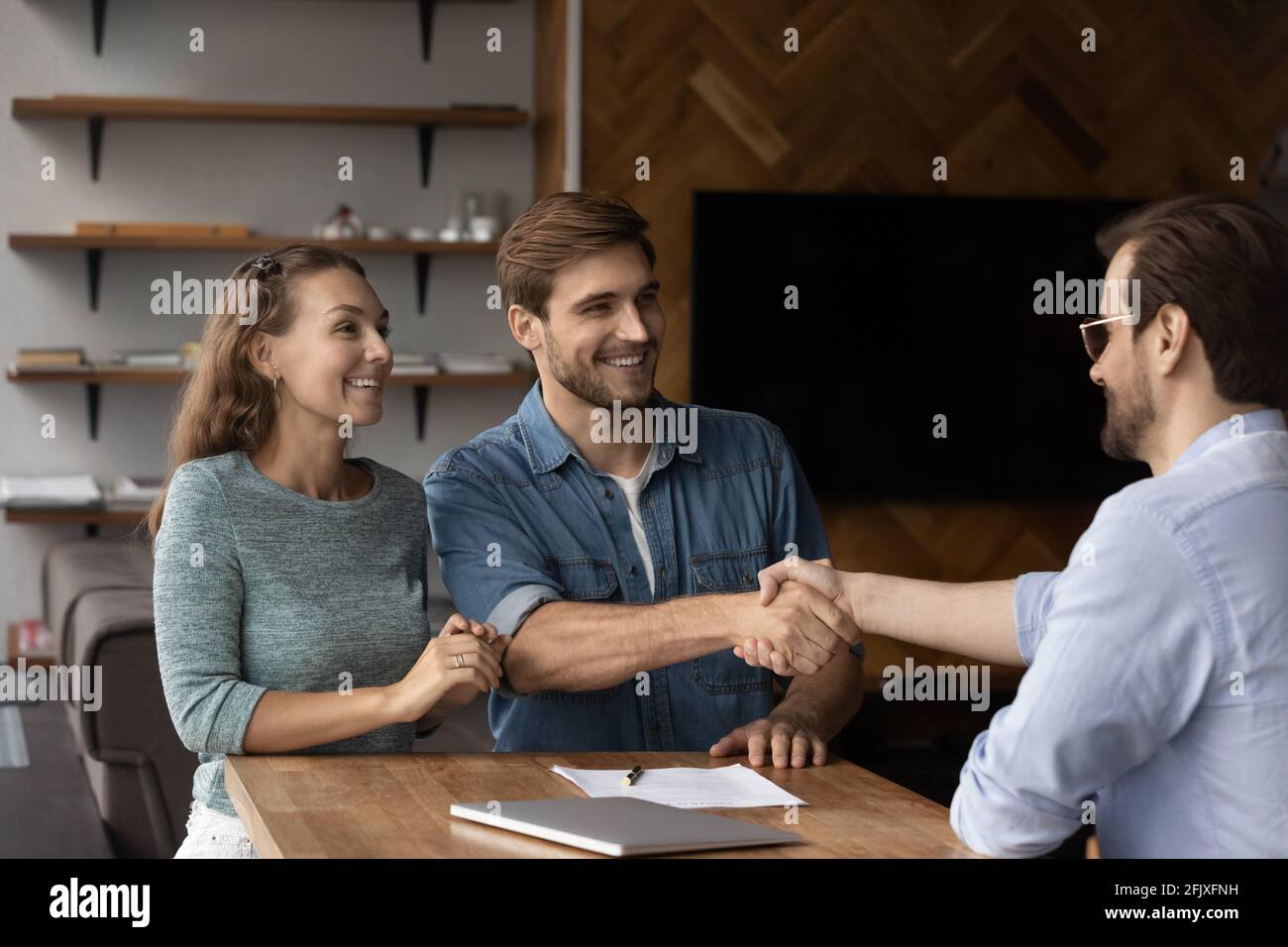 Happy couple clients handshake male consultant at meeting Stock Photo ...