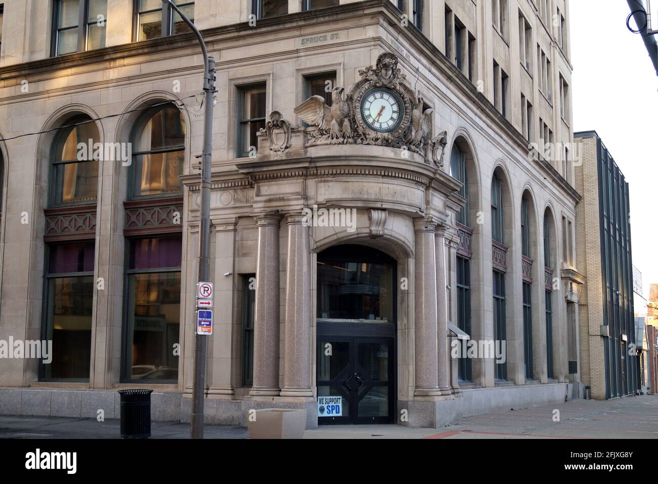 Ornate corner entry portal topped with a clock and sided by columns, of ...