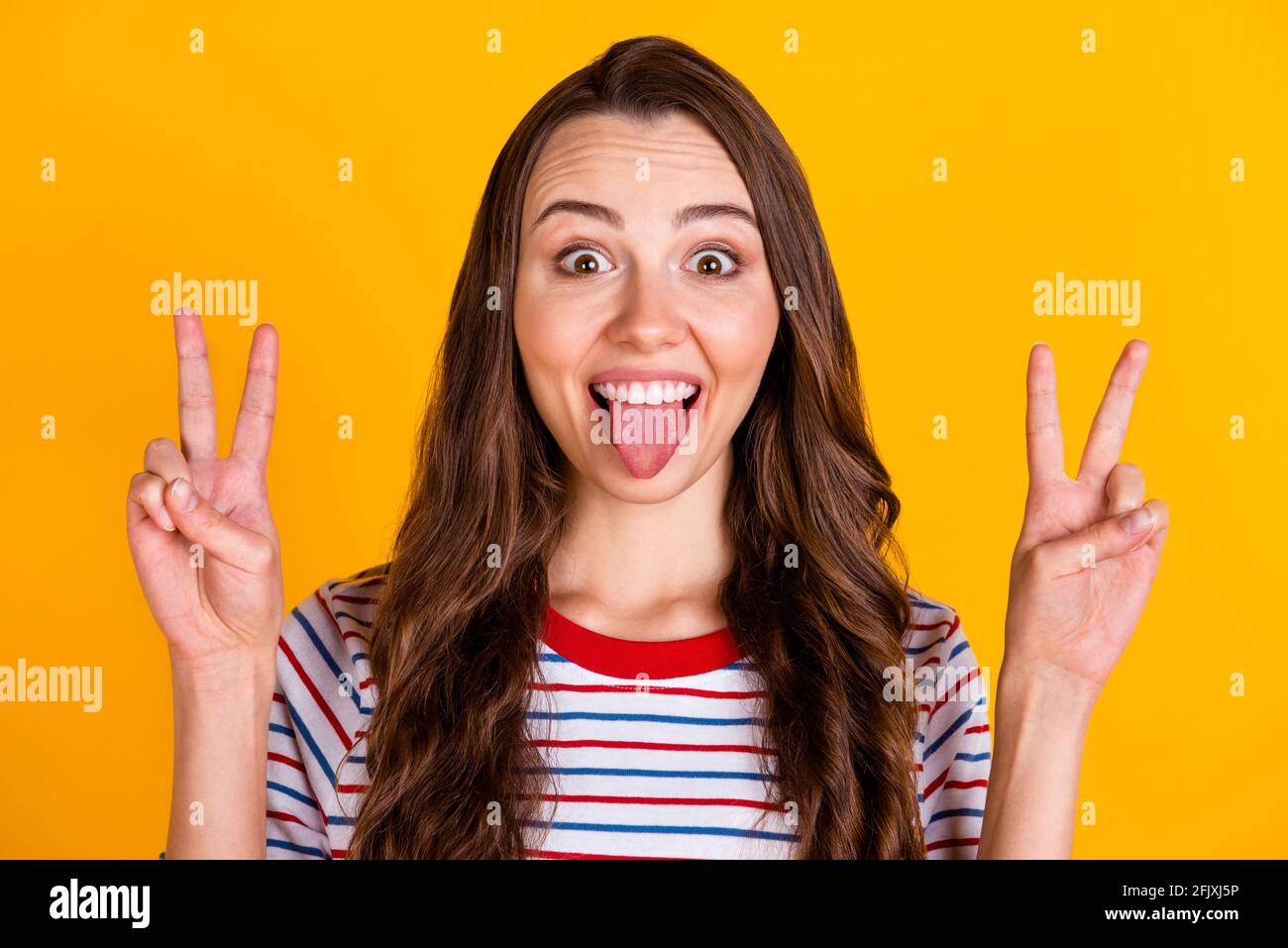 Close-up portrait of attractive cheerful funky girl showing double v ...