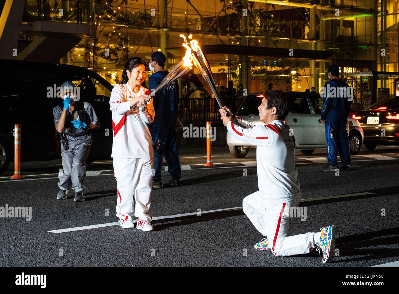 Local torchbearers pass the Olympic flame during the Tokyo 2020 Olympic ...