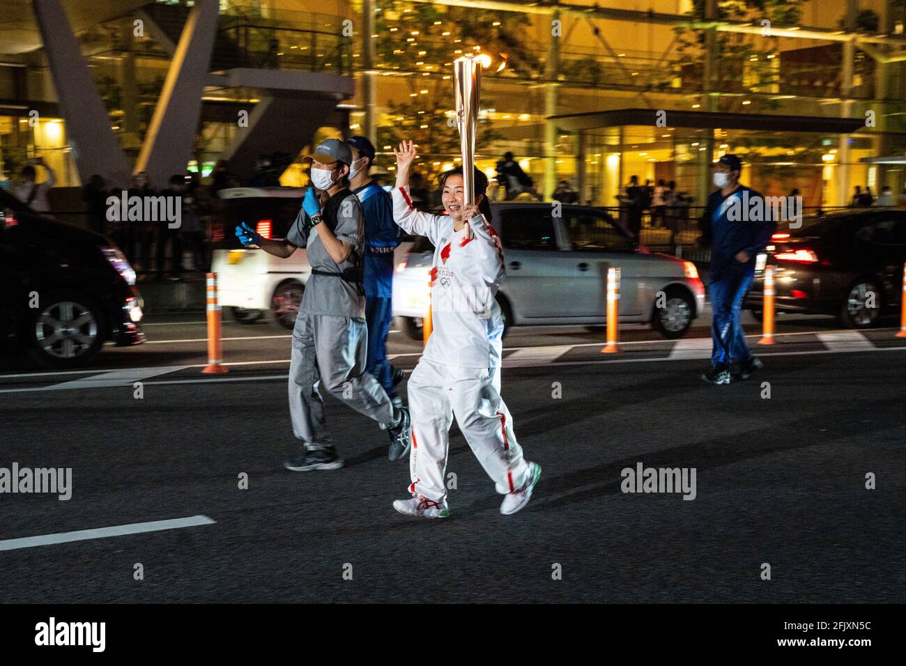 A local torchbearer runs during the Tokyo 2020 Olympic torch relay in ...