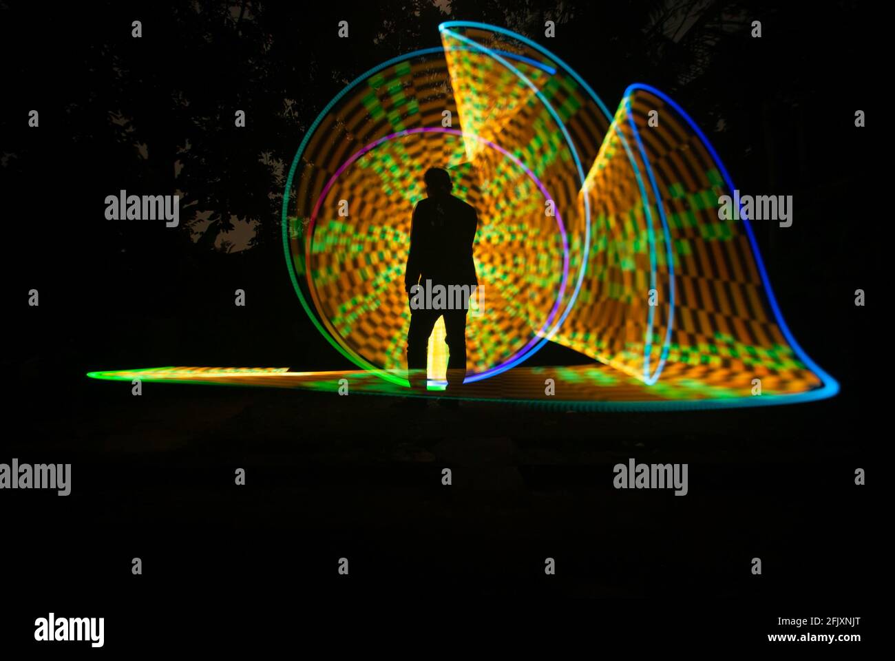 One person standing alone against beautiful color circle LED light ...