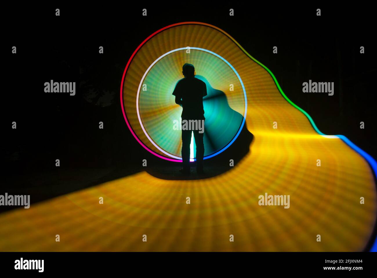 One person standing alone against beautiful color circle LED light ...