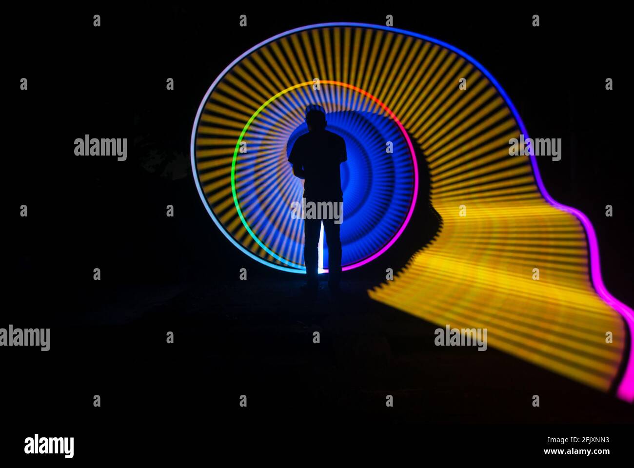 One person standing alone against beautiful color circle LED light ...