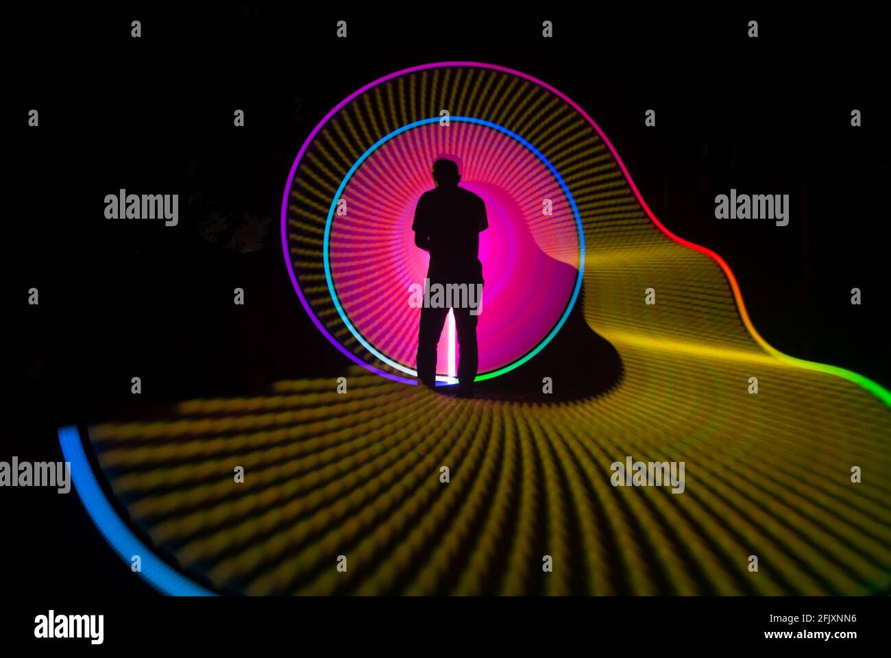 One person standing alone against beautiful color circle LED light ...