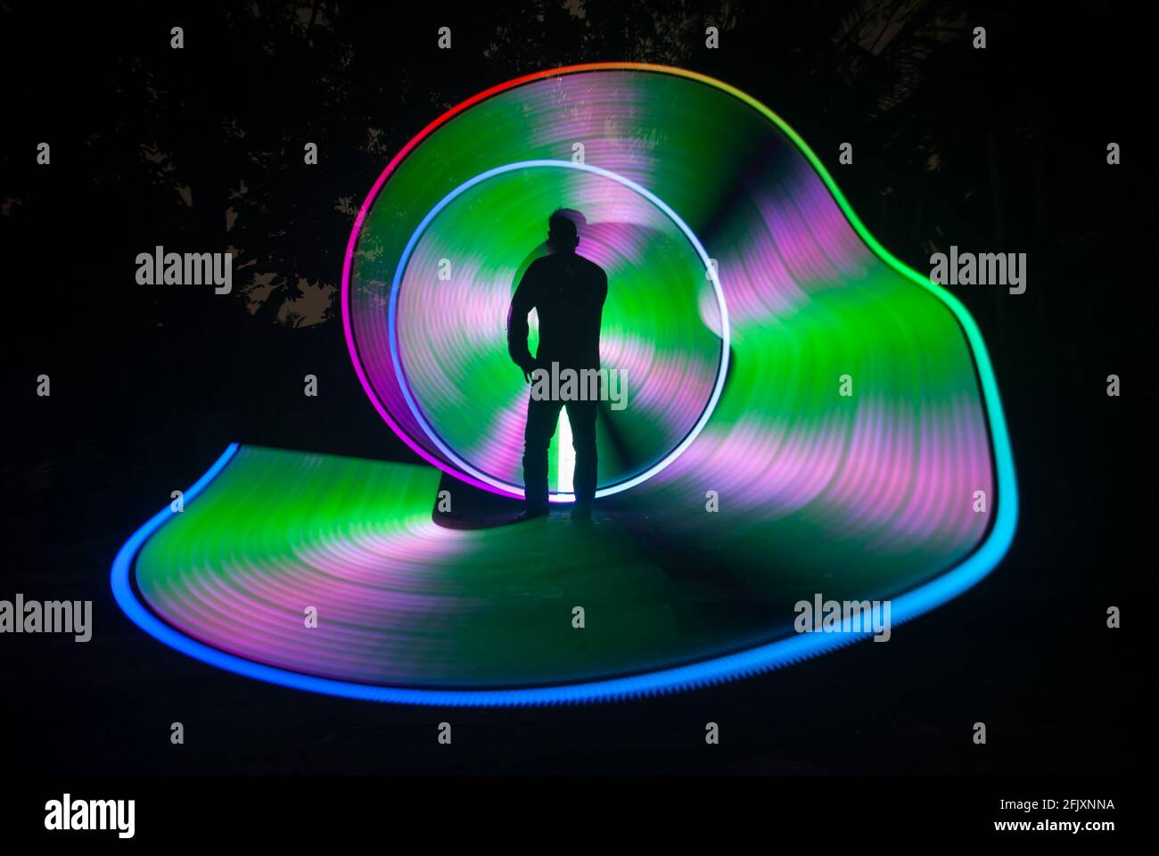 One person standing alone against beautiful color circle LED light ...