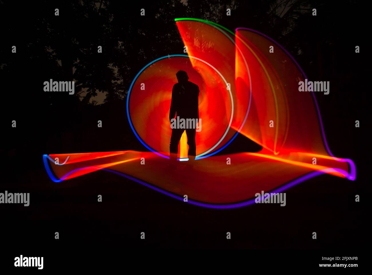One person standing alone against beautiful color circle LED light ...