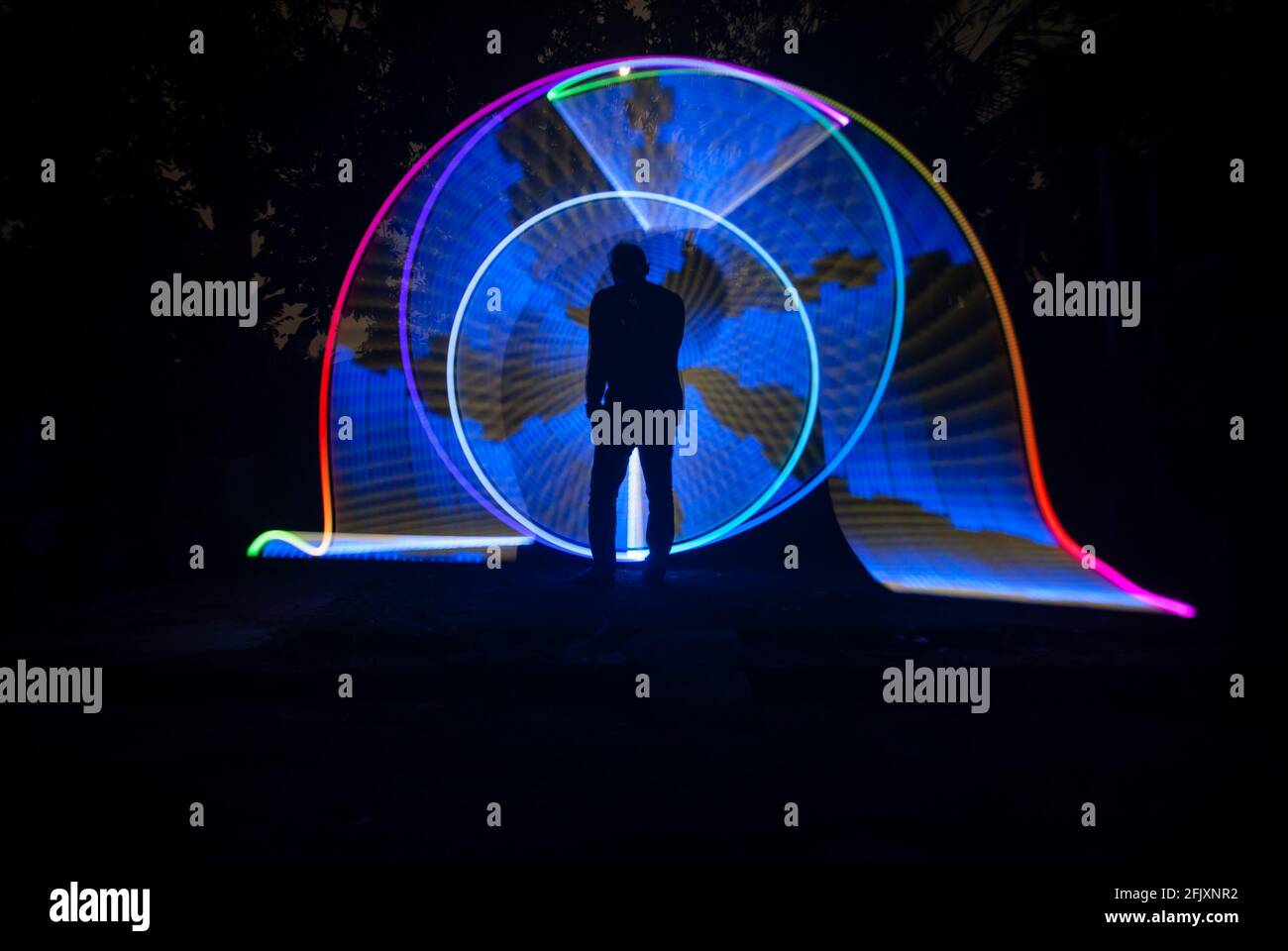 One person standing alone against beautiful color circle LED light ...