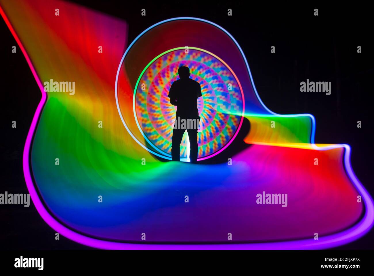 One person standing alone against beautiful color circle LED light ...