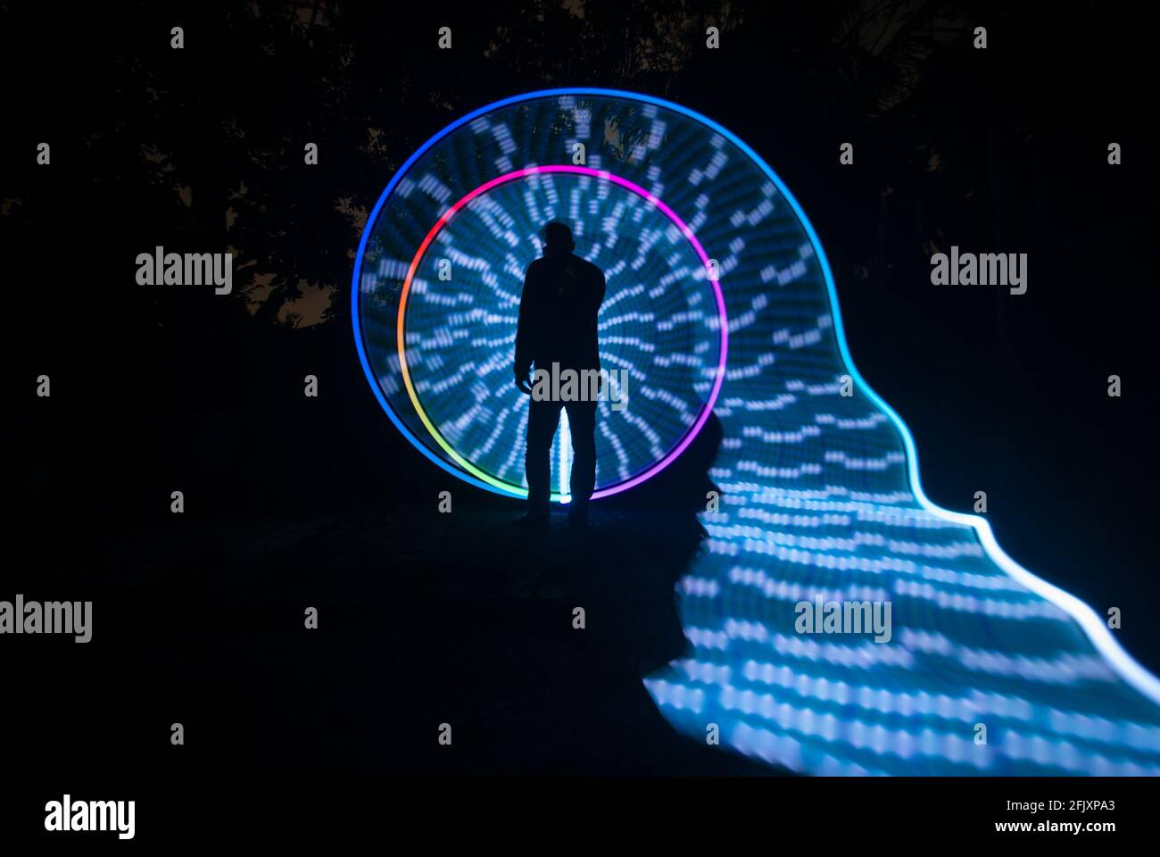One person standing alone against beautiful color circle LED light ...