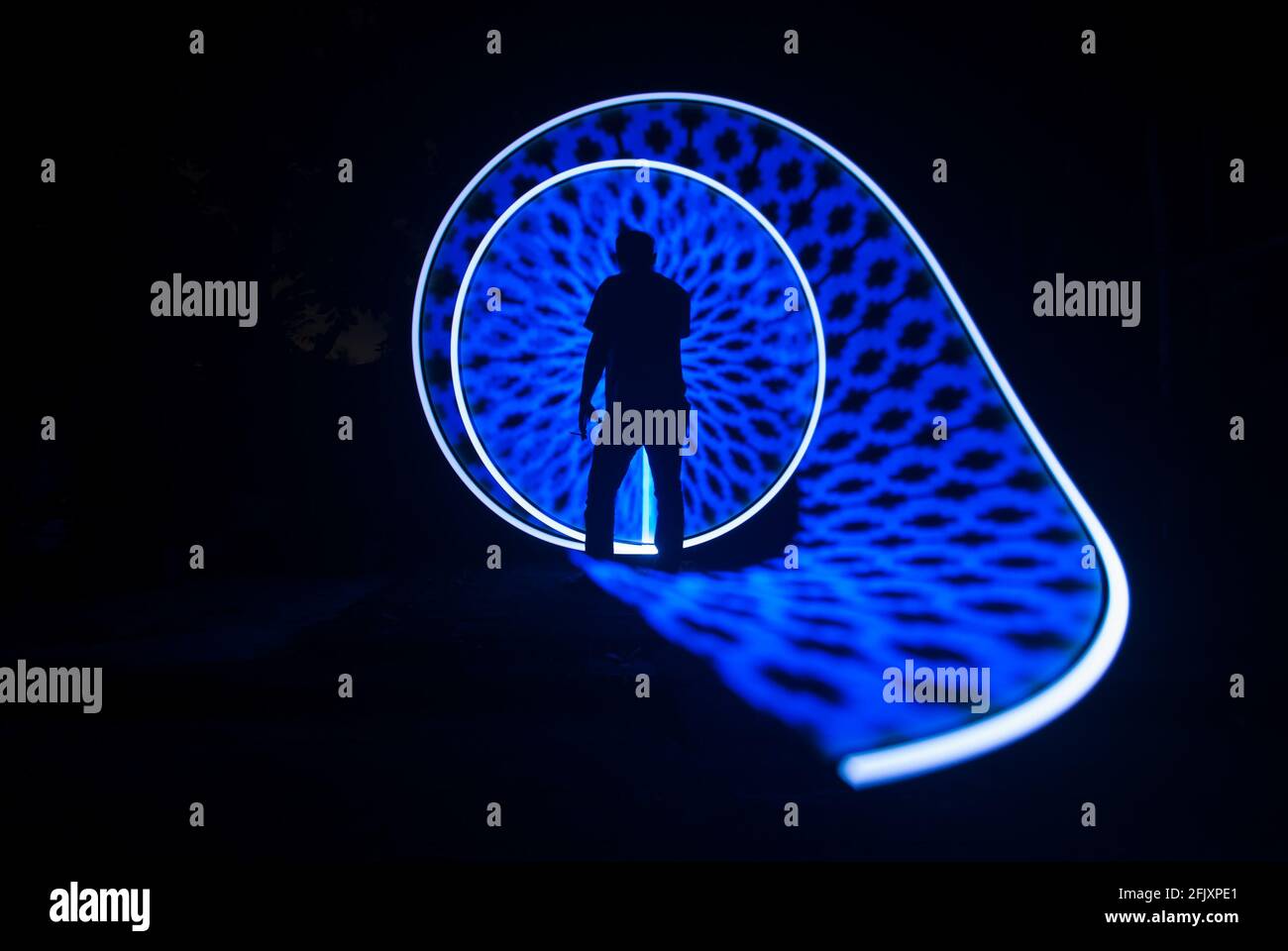 One person standing alone against beautiful color circle LED light ...