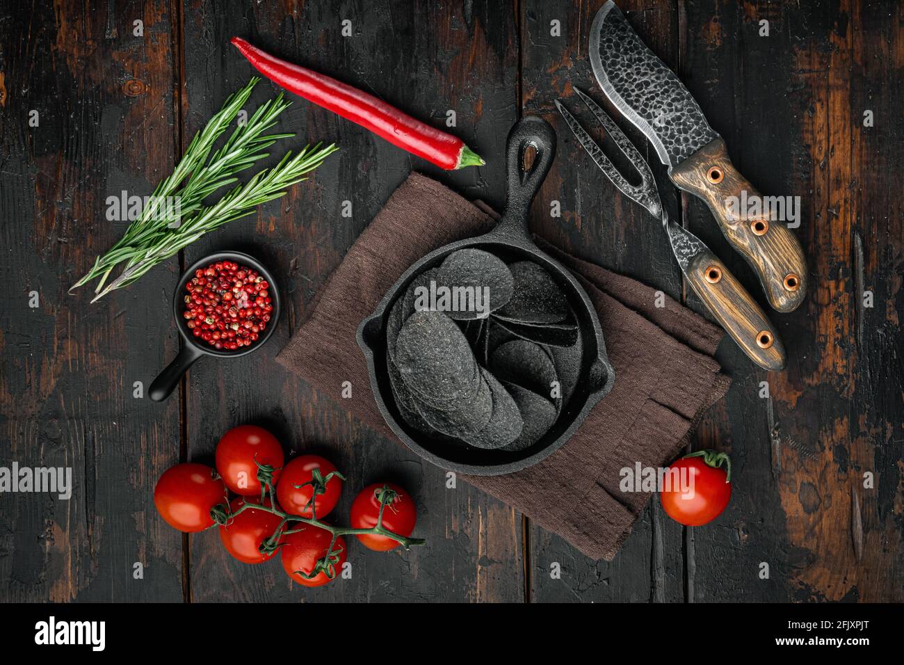 Black crispy potato chips set, on old dark wooden table, top view flat ...