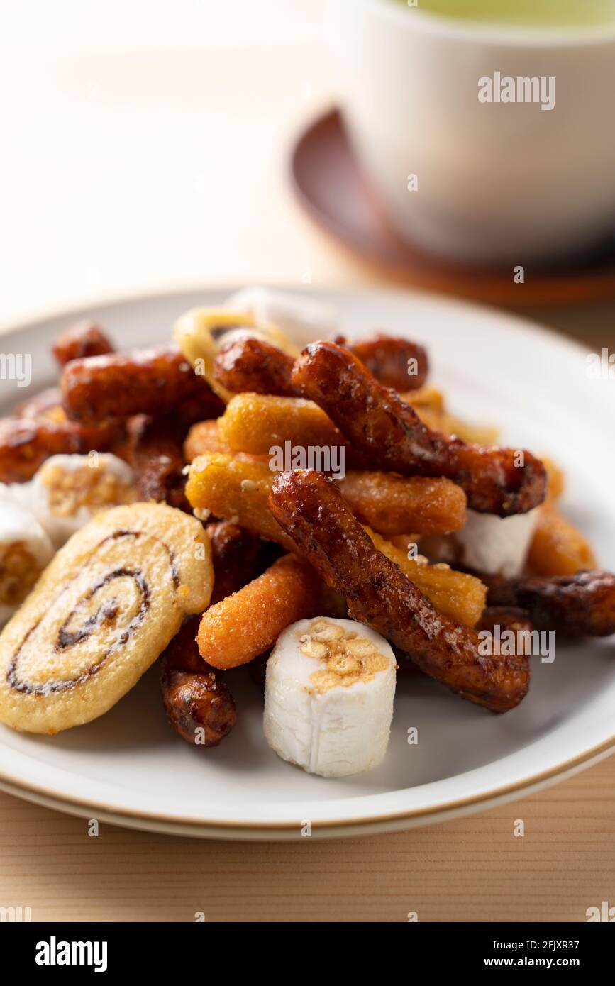 Various kinds of karinto and green tea placed on a wooden background ...