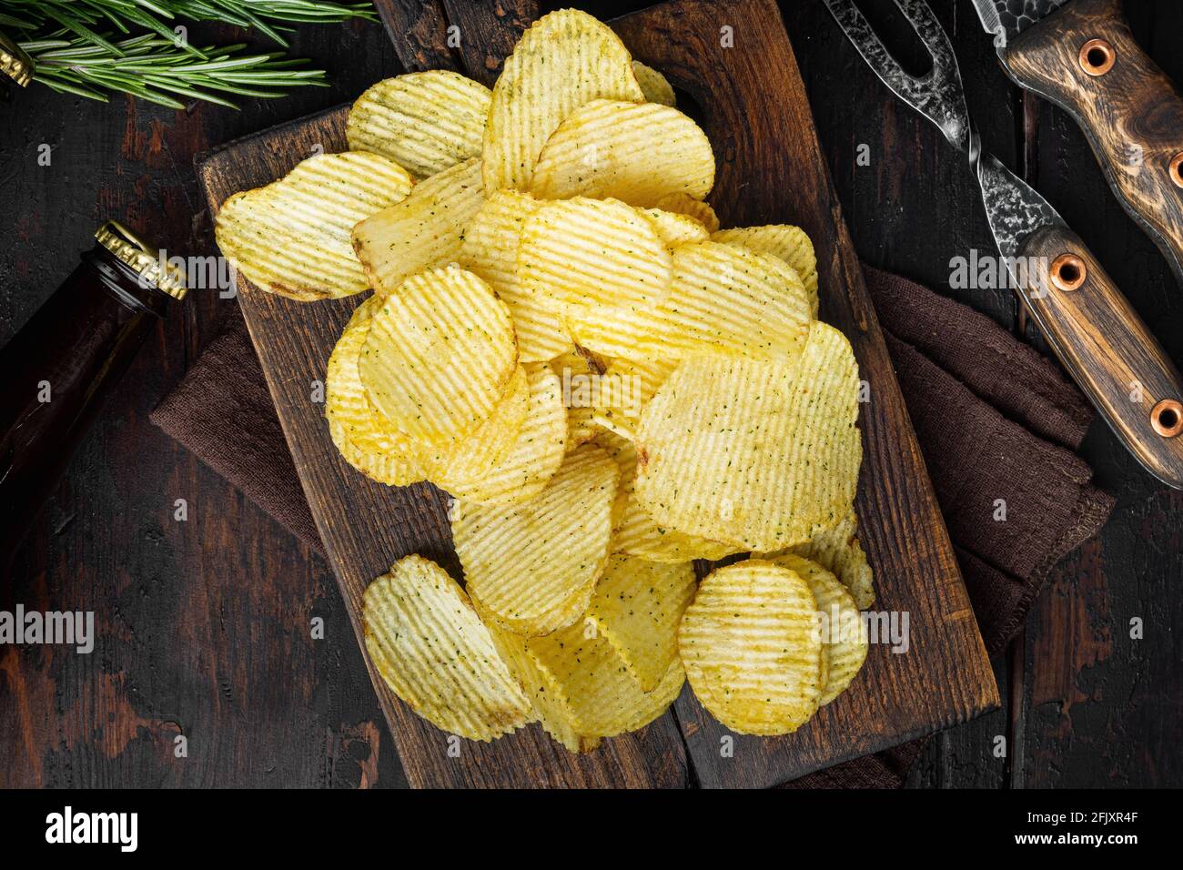 Home made potato chips set, on old dark wooden table, top view flat lay ...