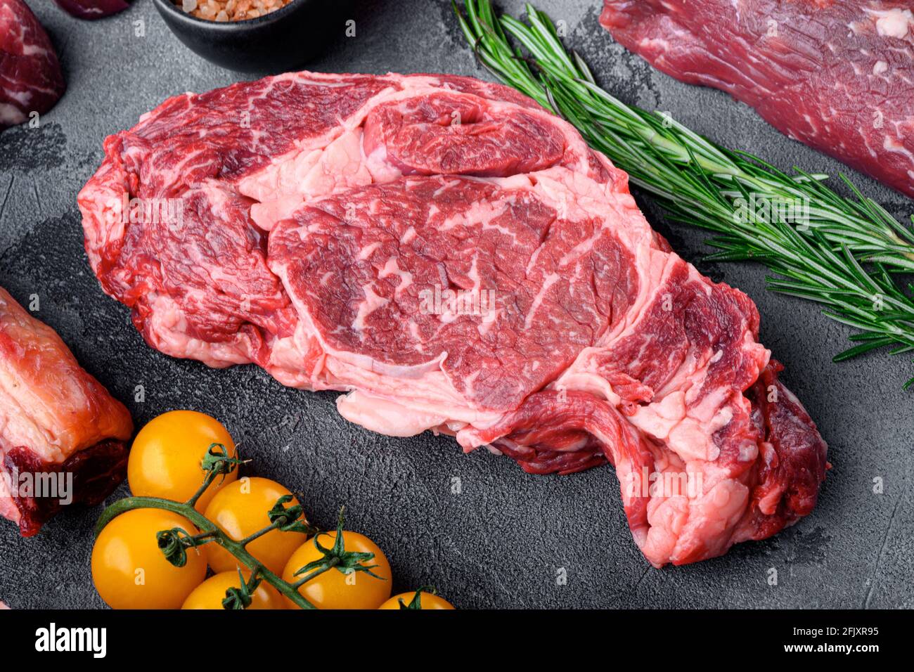 Rib eye steak of beef marbled meat or scotch fillet set, on gray stone ...