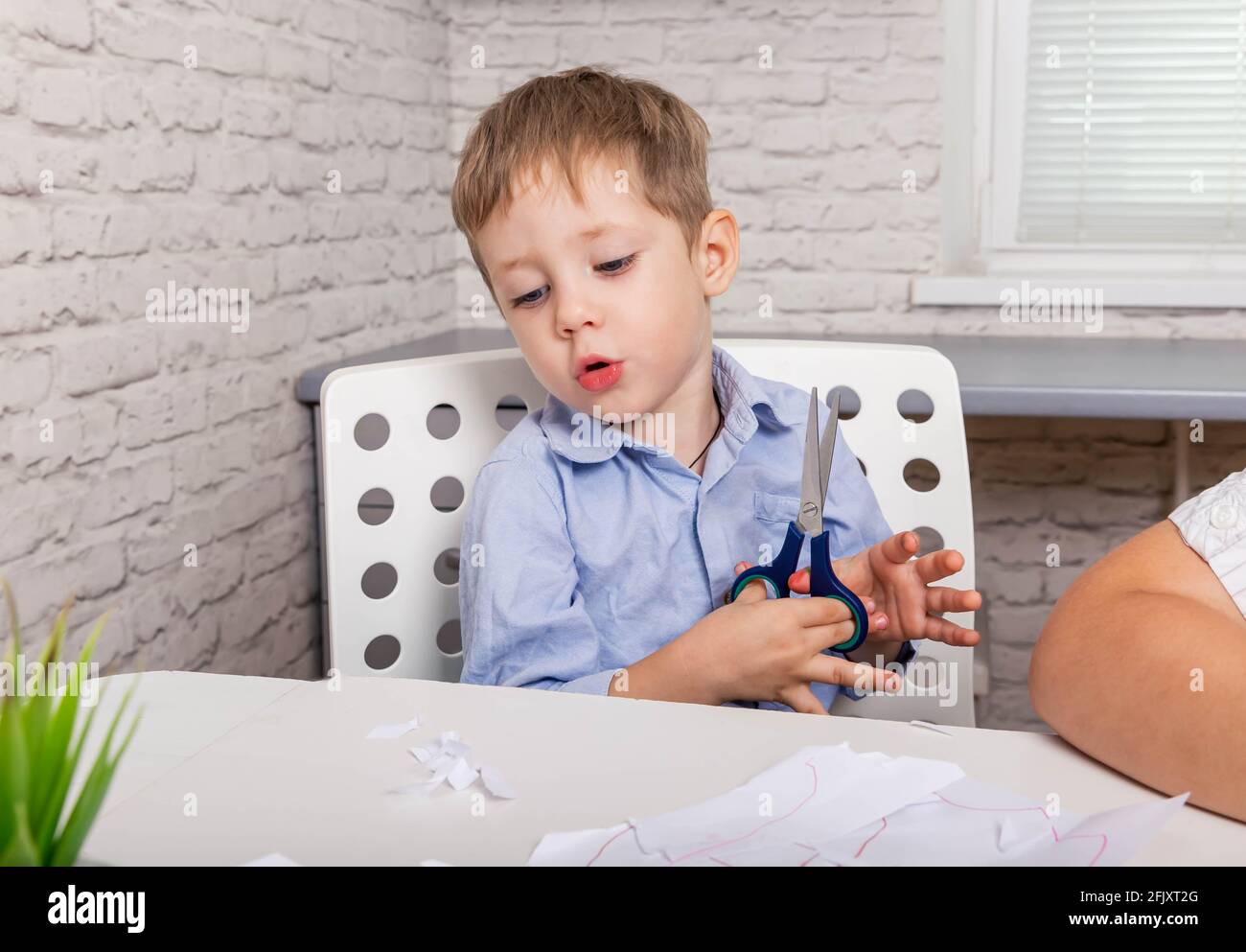 Kid cutting with scissors and gluing paper. Craft for children Stock ...
