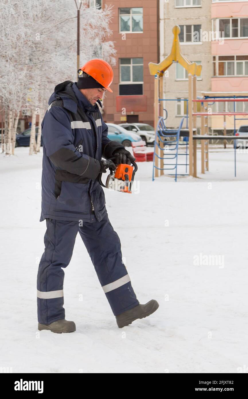 Worker with a chainsaw in hand at the assembly site Stock Photo - Alamy
