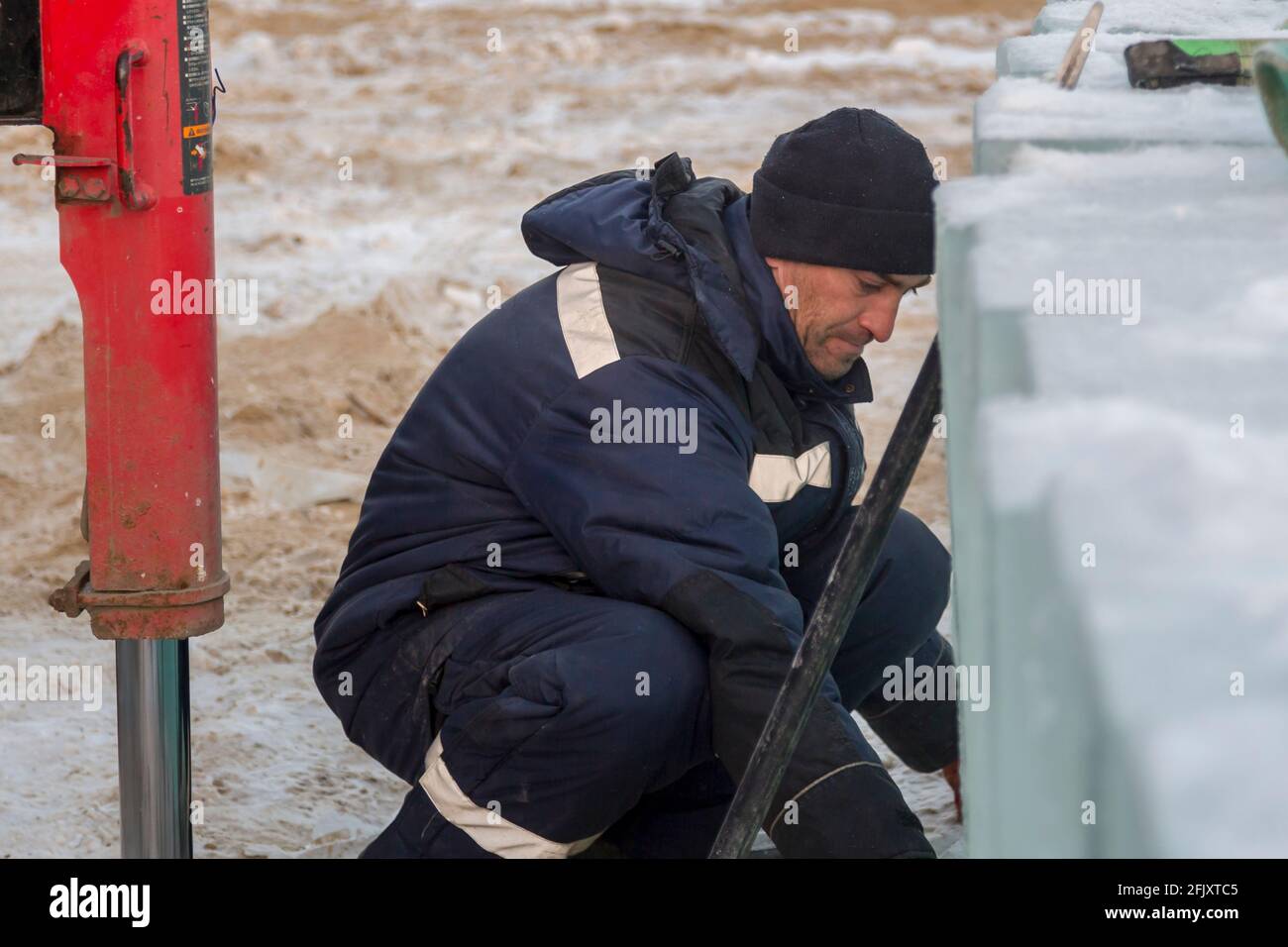 Worker with scrap metal in his hands loading ice blocks Stock Photo - Alamy