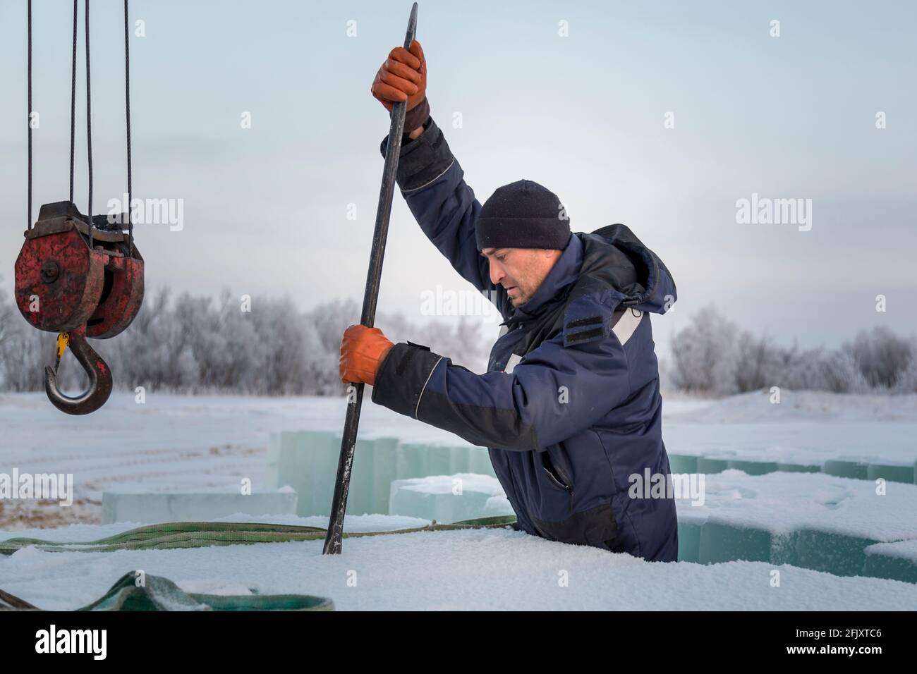 Worker with scrap metal in his hands loading ice blocks Stock Photo - Alamy