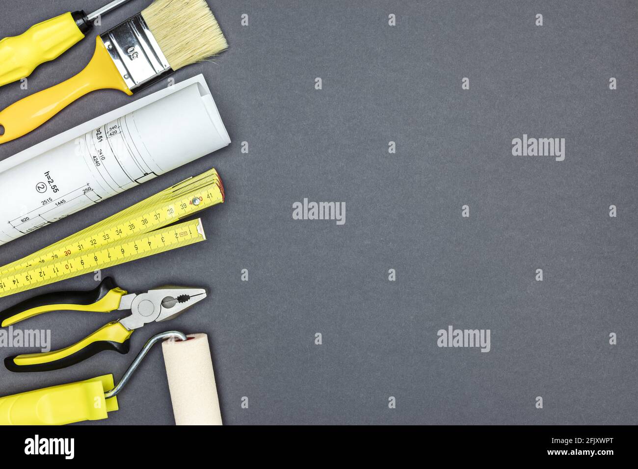 different working tools and architectural blueprint on dark grey ...