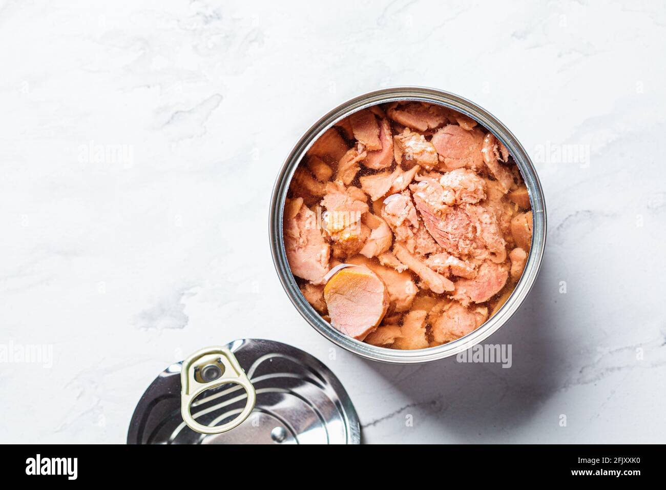 Open tin can of tuna, top view, white marble background. Canned food ...